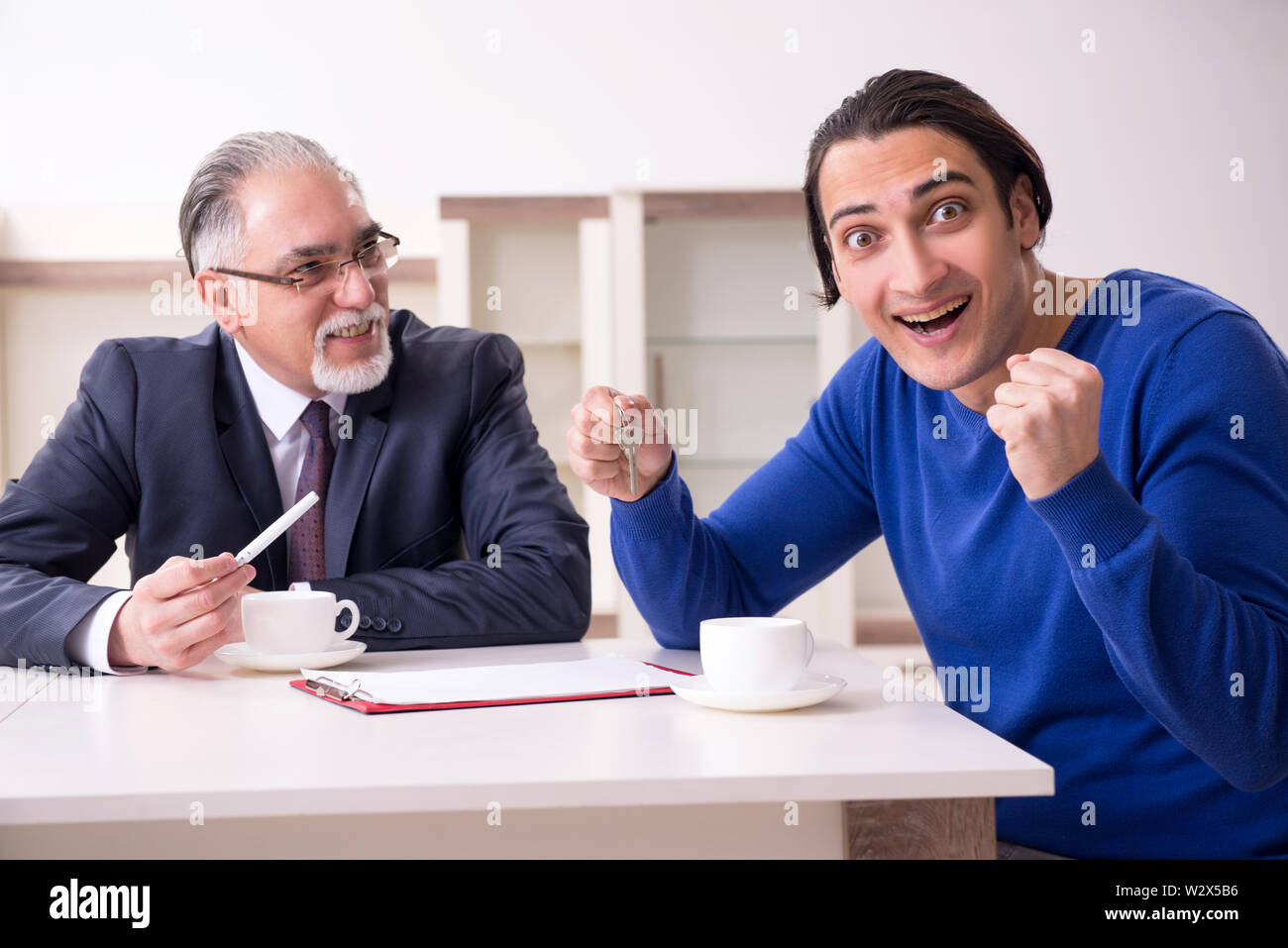 The male real estate agent and male client in the apartment Stock Photo ...