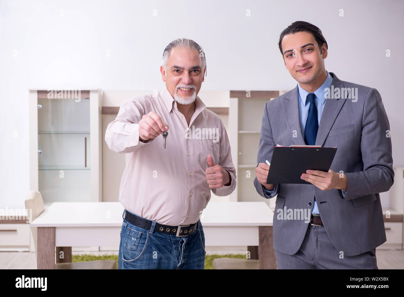 The male real estate agent and male client in the apartment Stock Photo ...