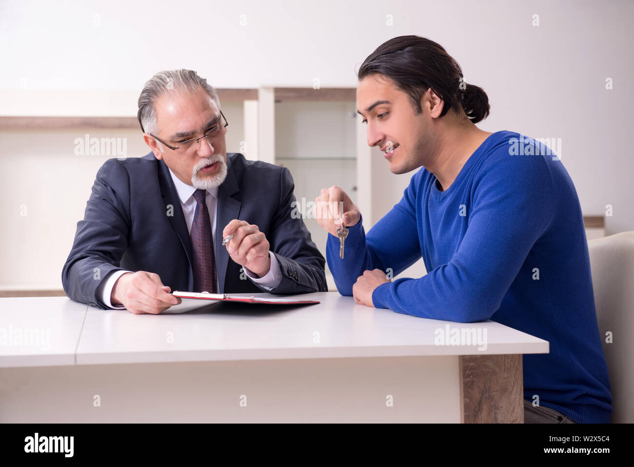 The male real estate agent and male client in the apartment Stock Photo ...