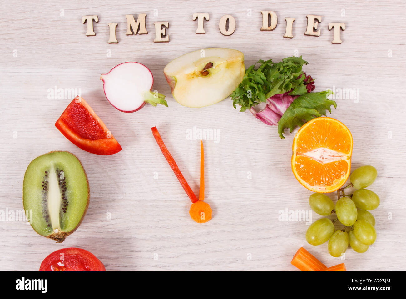 Fresh ripe fruits and vegetables in shape of clock showing time to diet ...