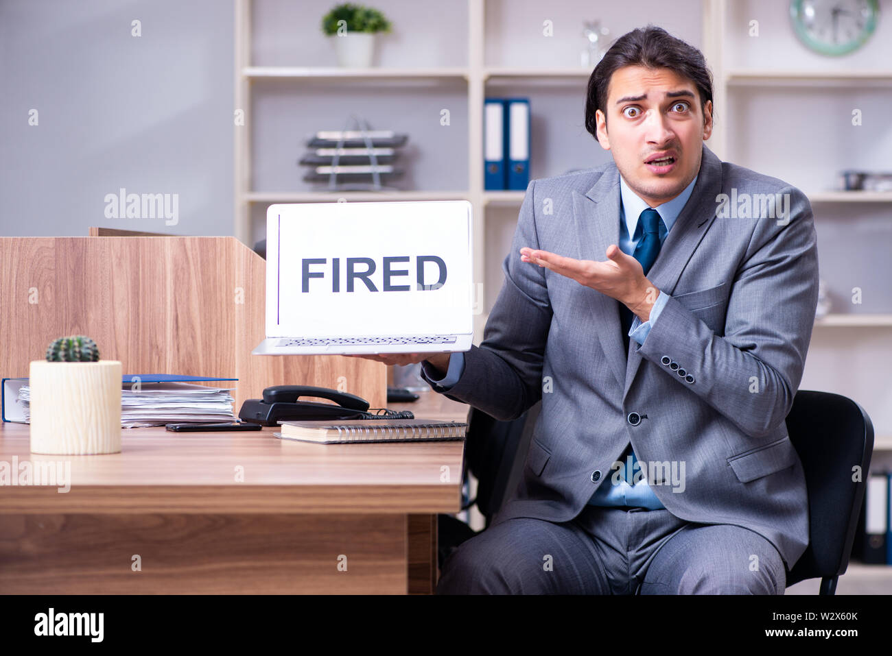 The young male employee being fired from his work Stock Photo - Alamy