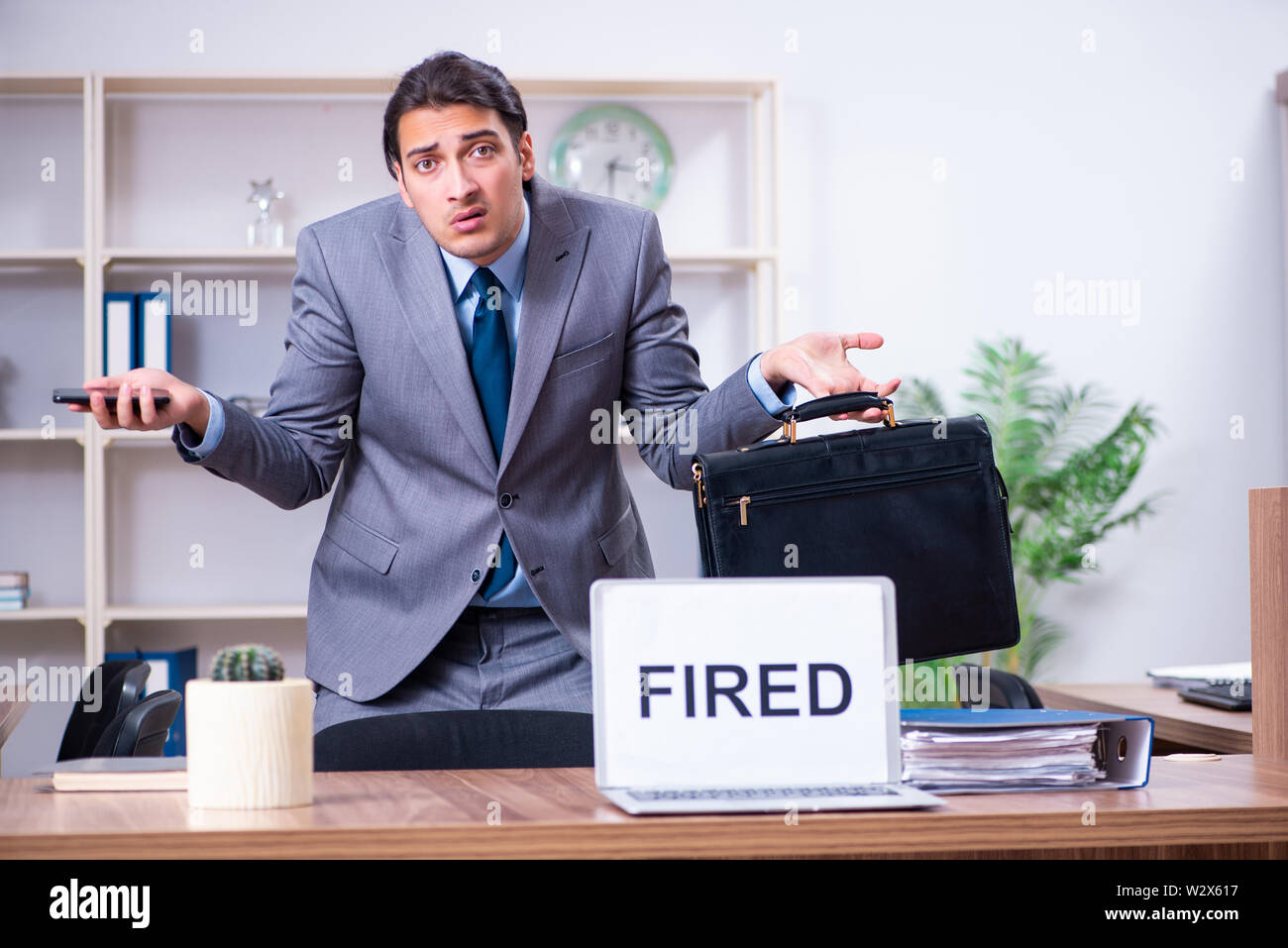 The young male employee being fired from his work Stock Photo - Alamy