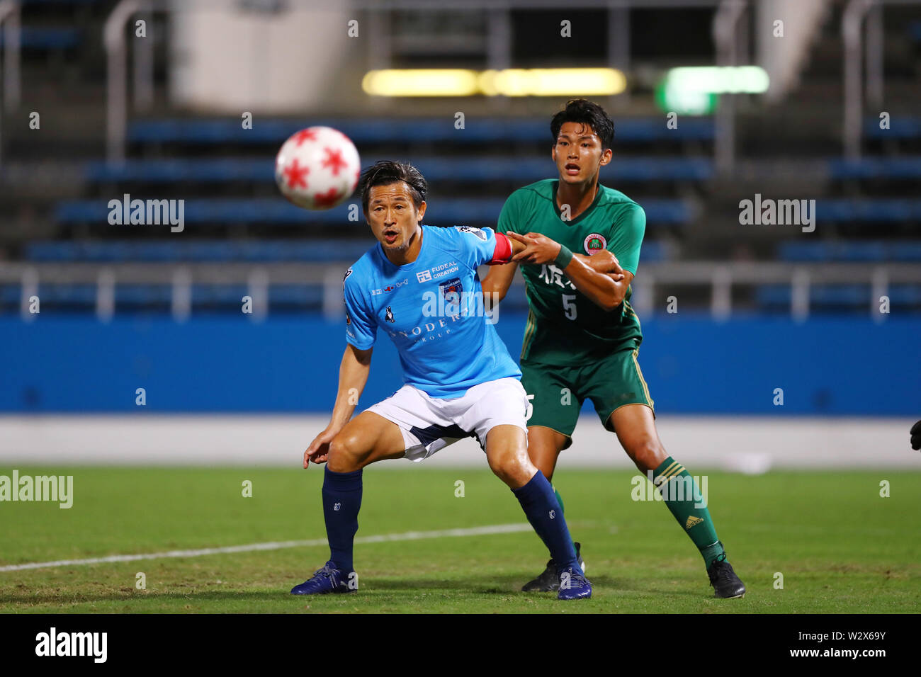 Yokohama FC's Kazuyoshi Miura and Sendai University's Yuta Motoyoshi ...