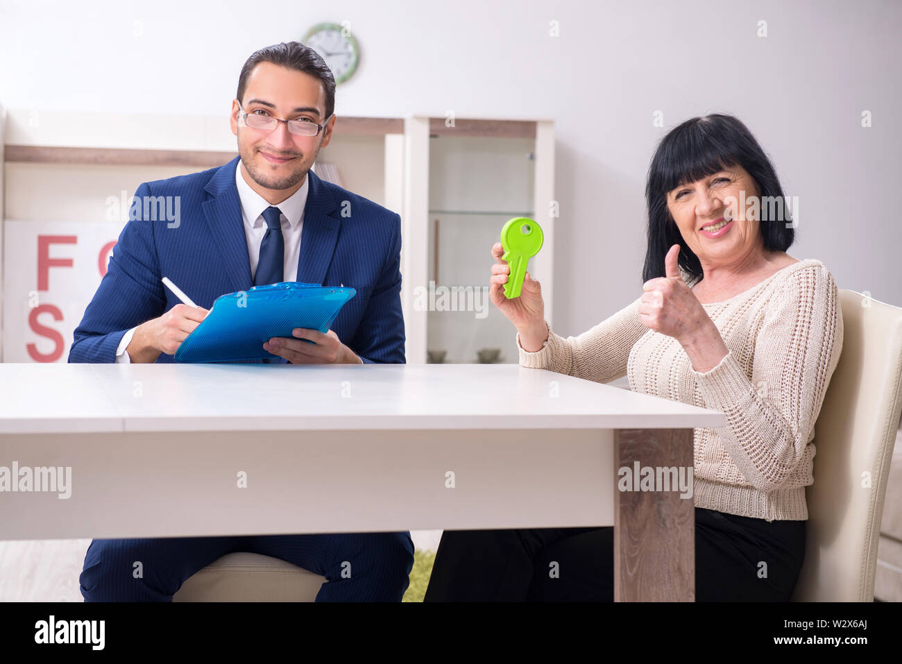 The male real estate agent and female client in the apartment Stock ...