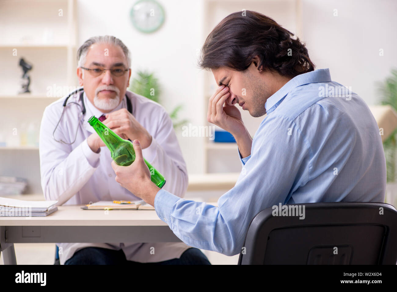 The young male alcoholic visiting old doctor Stock Photo - Alamy