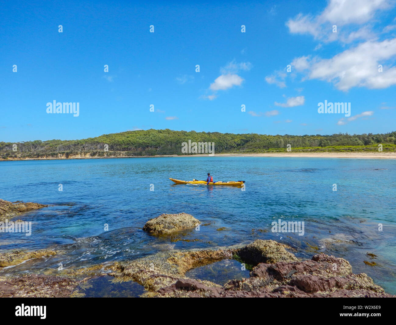 Young man in single kayak floating in ocean bay near Batemans Bay, NSW ...