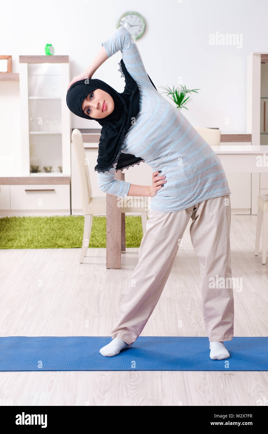 The young woman in hijab doing exercises at home Stock Photo - Alamy