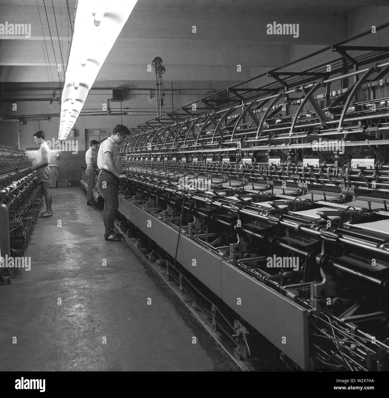 1950s, historical, three male workers standing using mechanical ...