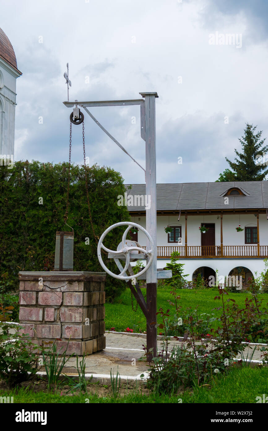 old well with manual turning wheel and bucket outside Cernica Monastery ...