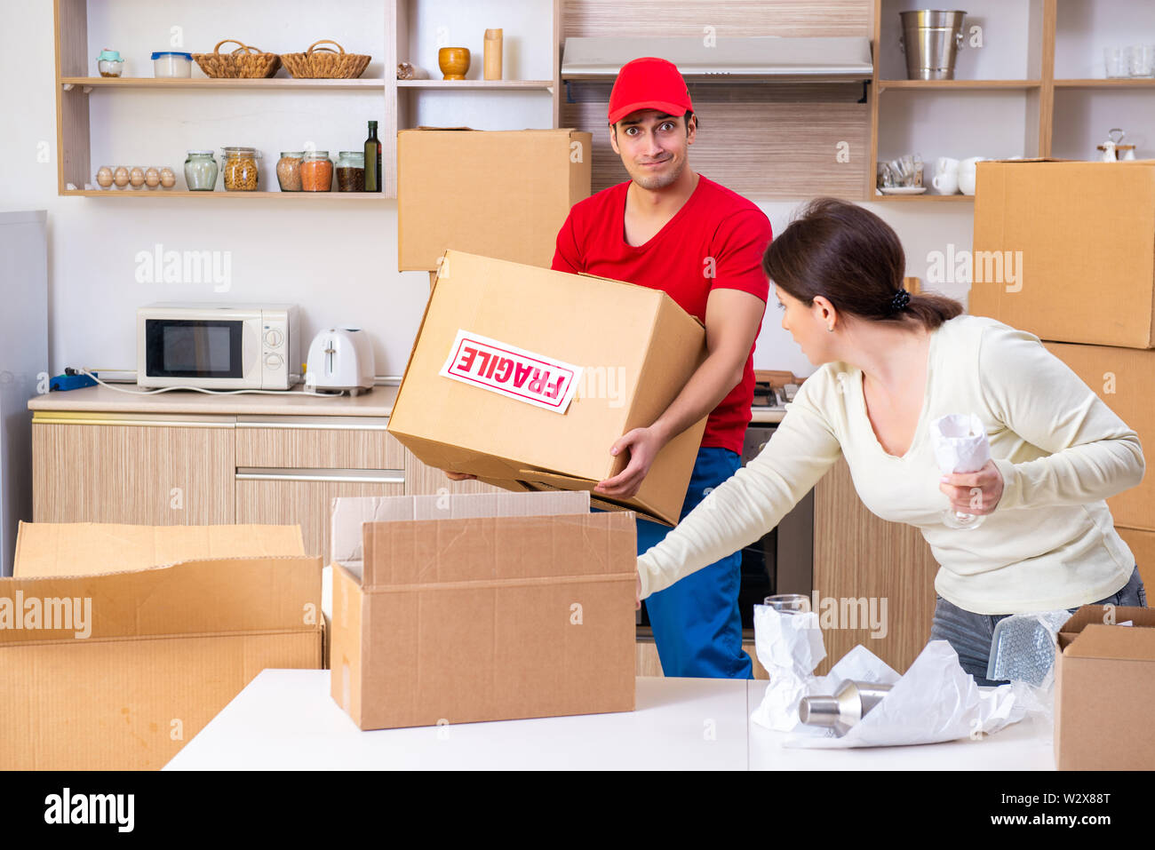 The young male contractor and female customer in moving concept Stock ...
