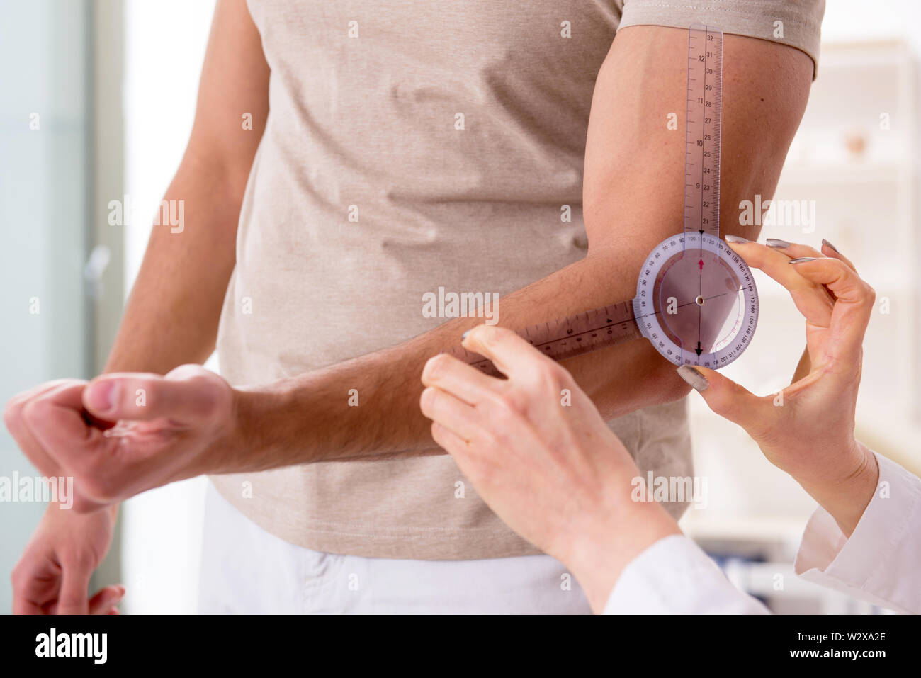 The female doctor checking patient's joint flexibility with goniometer ...