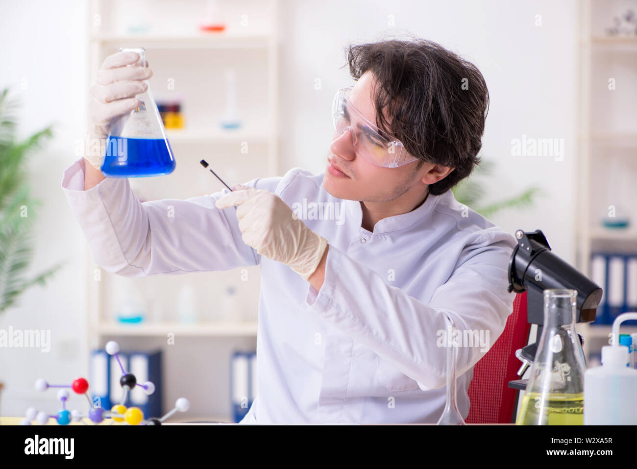 The young male biochemist working in the lab Stock Photo - Alamy