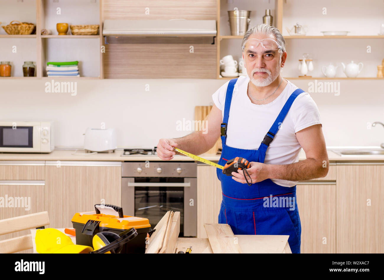 The aged contractor repairman working in the kitchen Stock Photo - Alamy