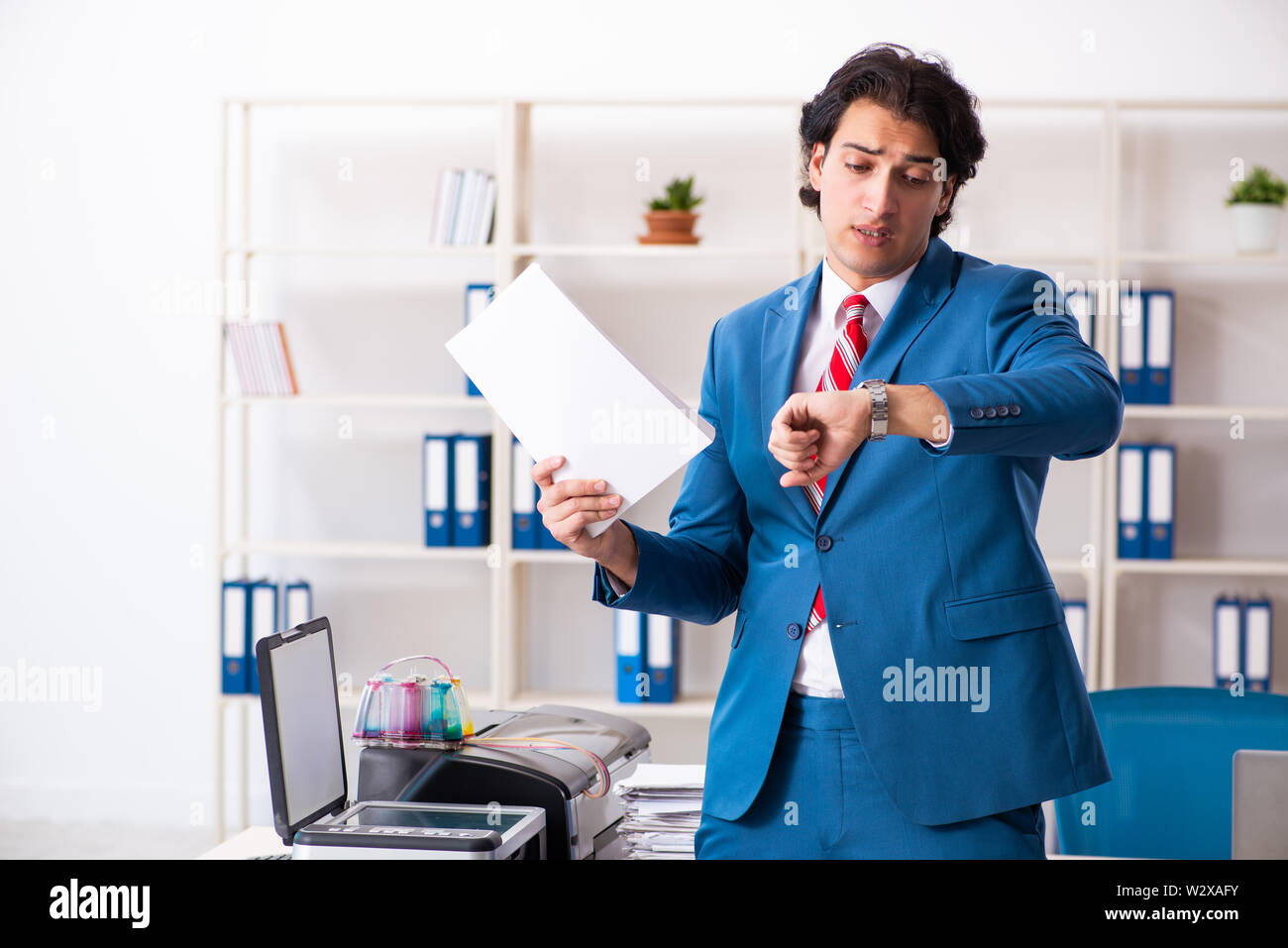 The young employee making copies at copying machine Stock Photo - Alamy