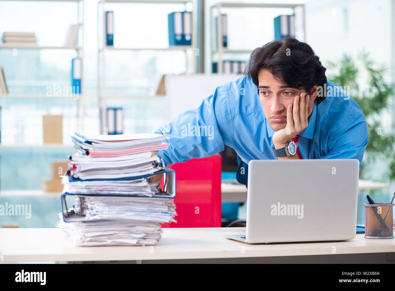The handsome businessman unhappy with excessive work in the office ...