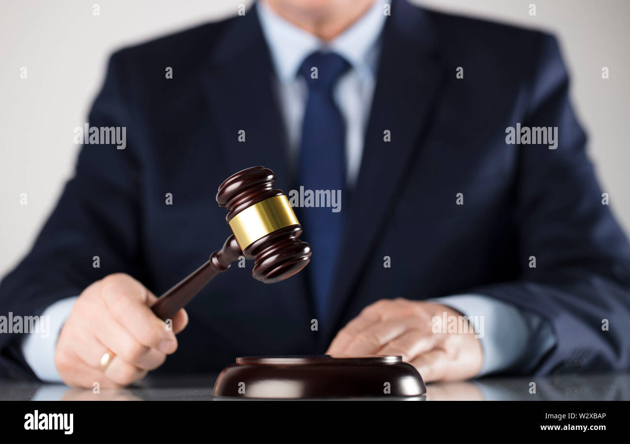 Judge in the courtroom. Male judge striking the gavel Stock Photo - Alamy