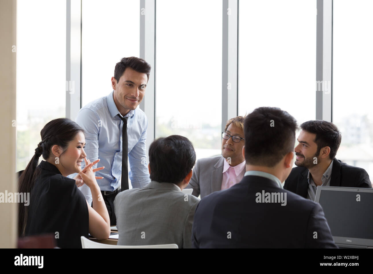 Chief businessman standing at conference table during team meeting ...