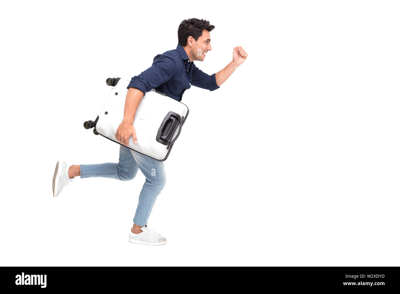 Handsome Caucasian tourist running fast and holding luggage on white ...