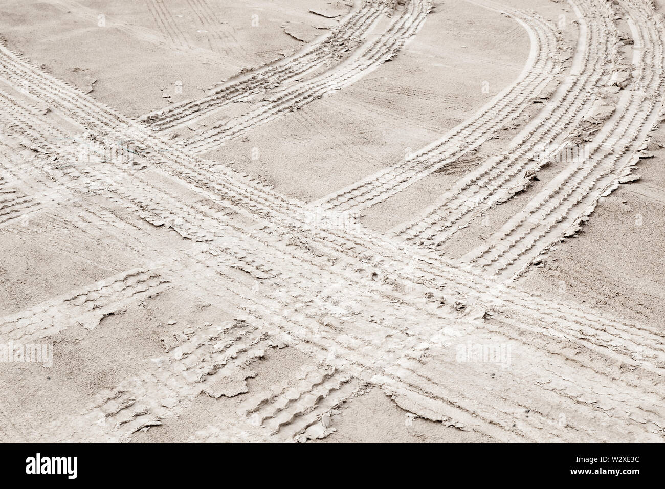 Crossing tire tracks on white wet sandy ground, off-road transportation ...