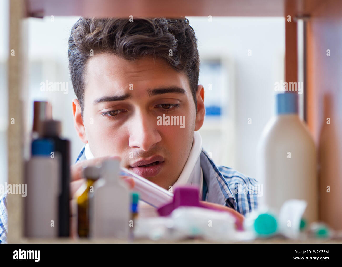 The sick ill man looking for medicines at farmacy shelf Stock Photo - Alamy