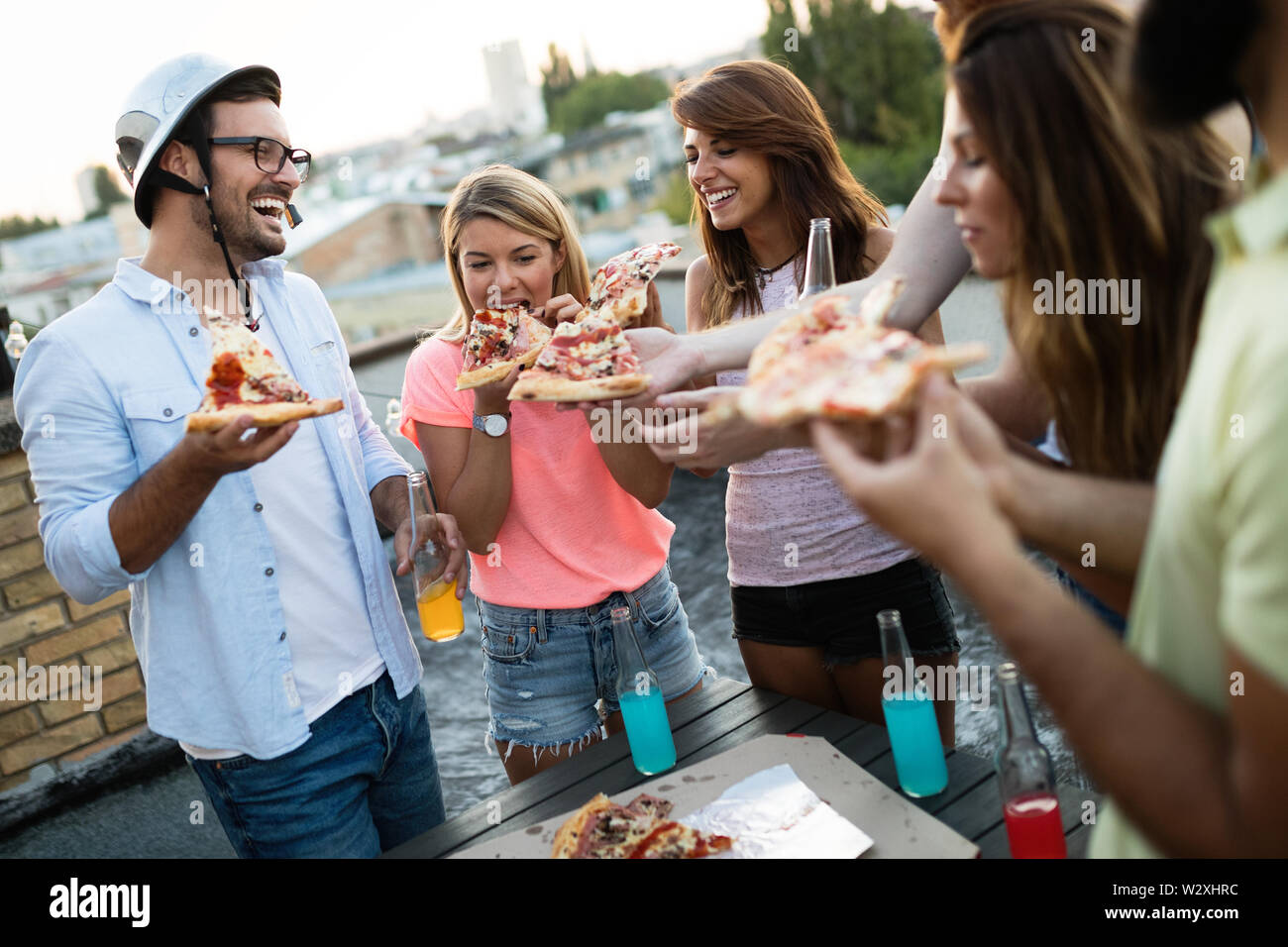 Friends and pizza. Young cheerful people eating pizza and having fun ...