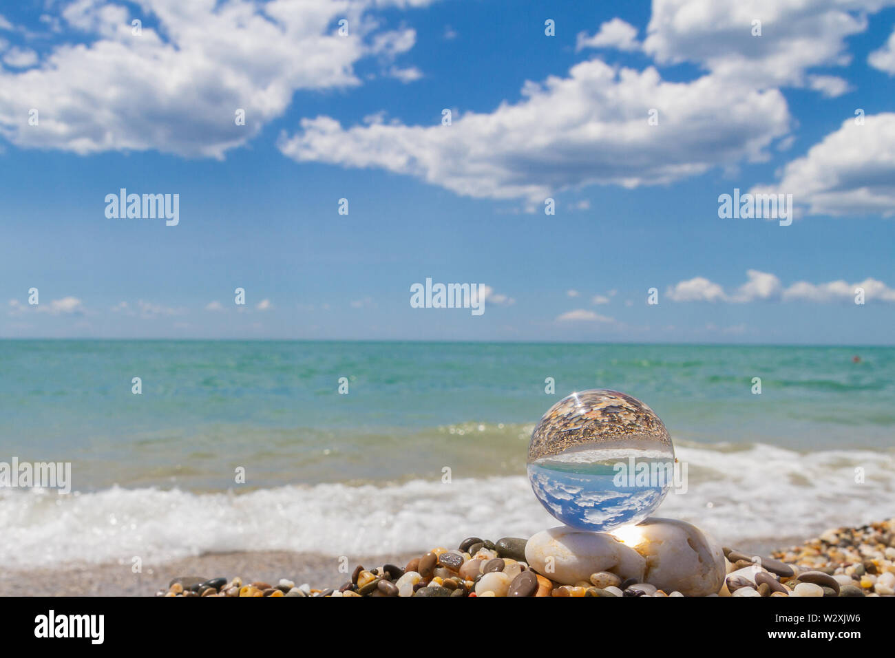 Glass round ball on the beach reflects the sea in summer Stock Photo ...