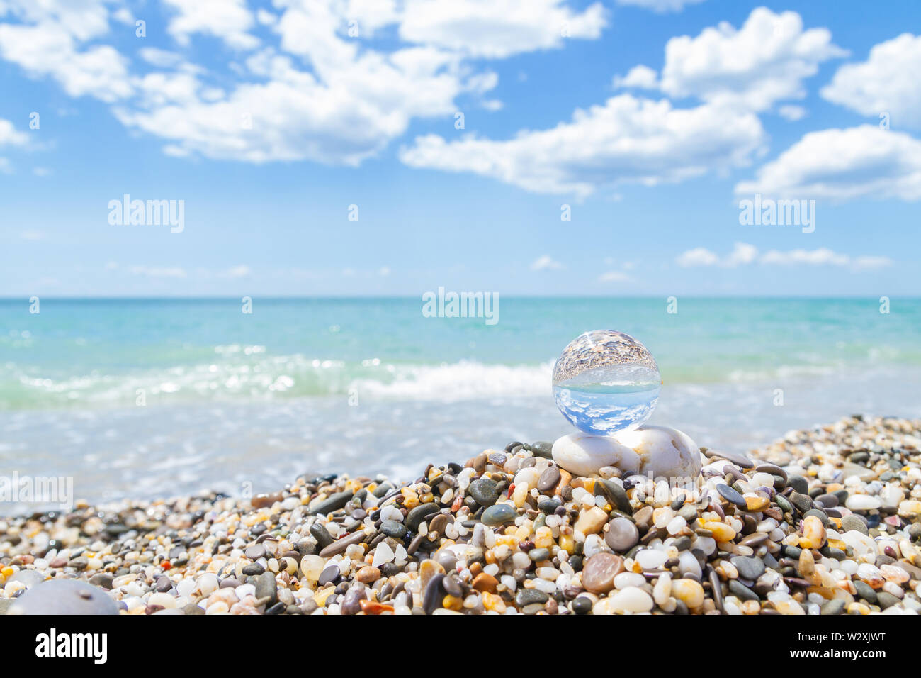 Glass round ball on the beach reflects the sea in summer Stock Photo ...