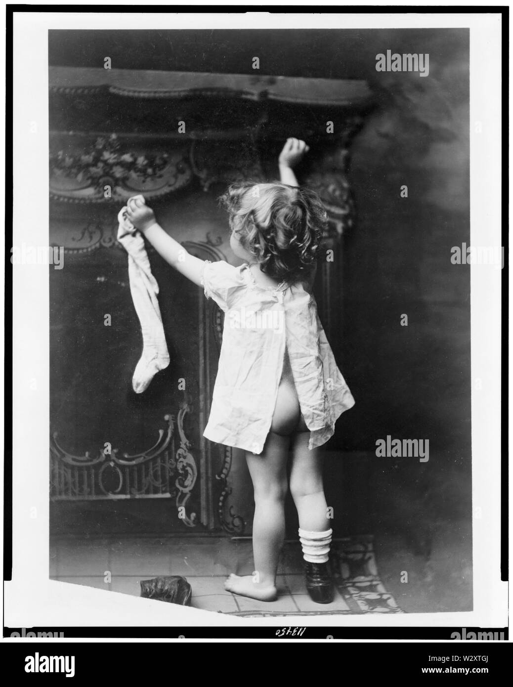 Little girl hanging up stocking by fireplace, retouched Stock Photo - Alamy