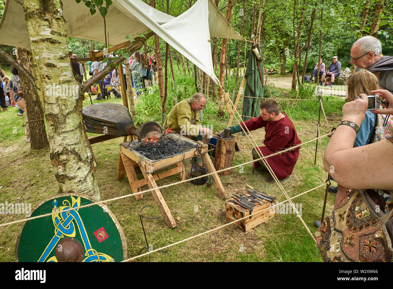 A blacksmithing demonstration of Viking methods while onlookers take ...