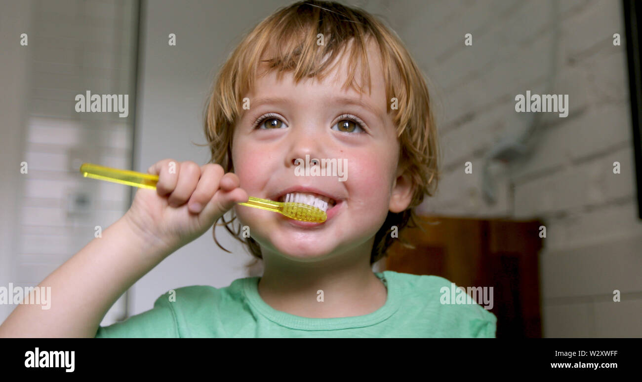 Little blond boy learning brushing his teeth Stock Photo - Alamy
