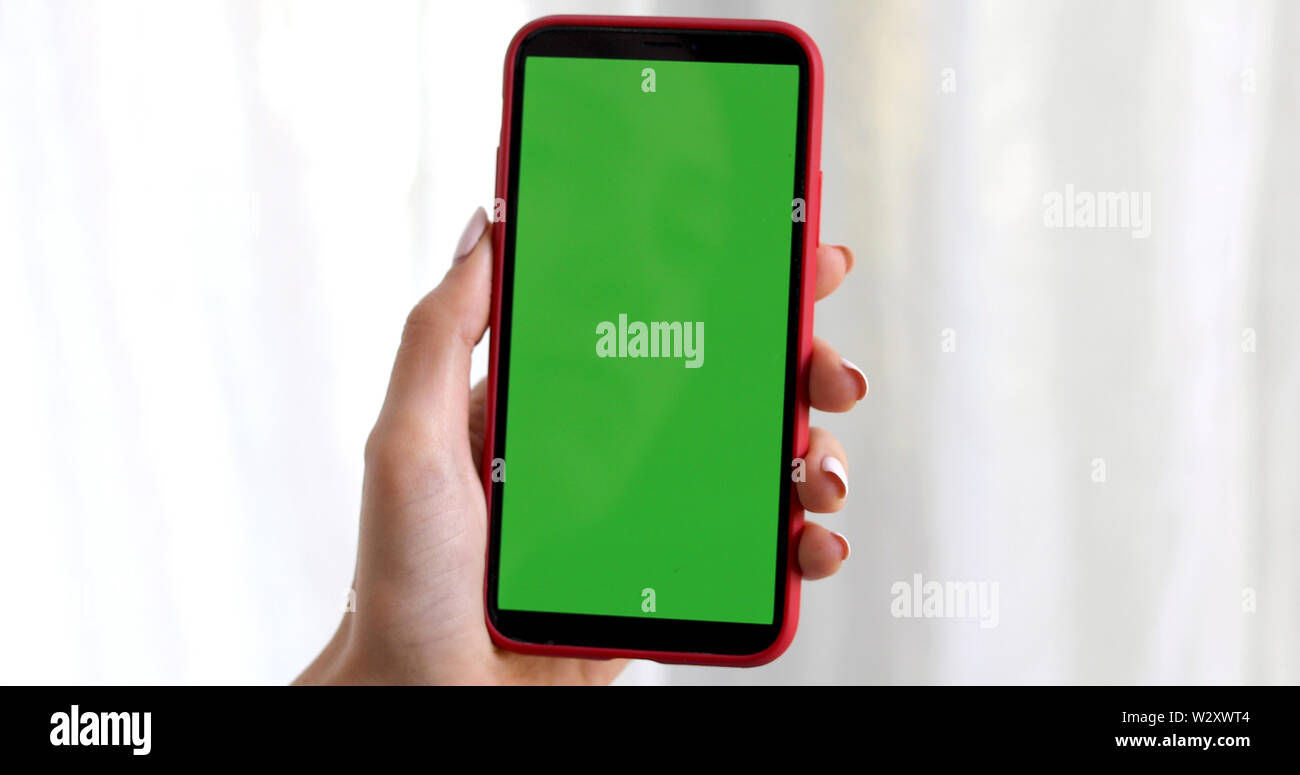 Female hand with a green screen smartphone Stock Photo - Alamy