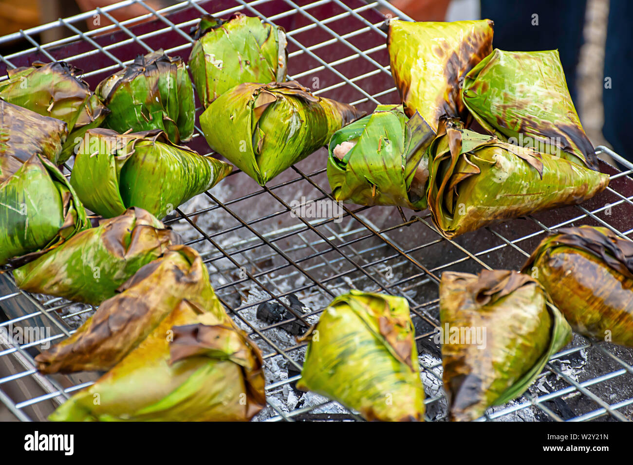 Sticky rice wrapped in banana leaves, roasted on the grill is a popular ...