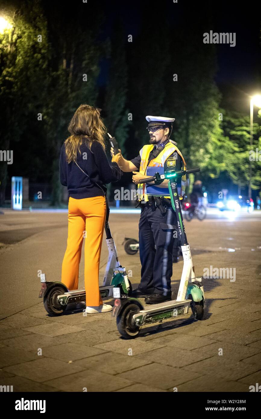 10 July 2019, Bavaria, Munich: A police officer uses a breath alcohol ...