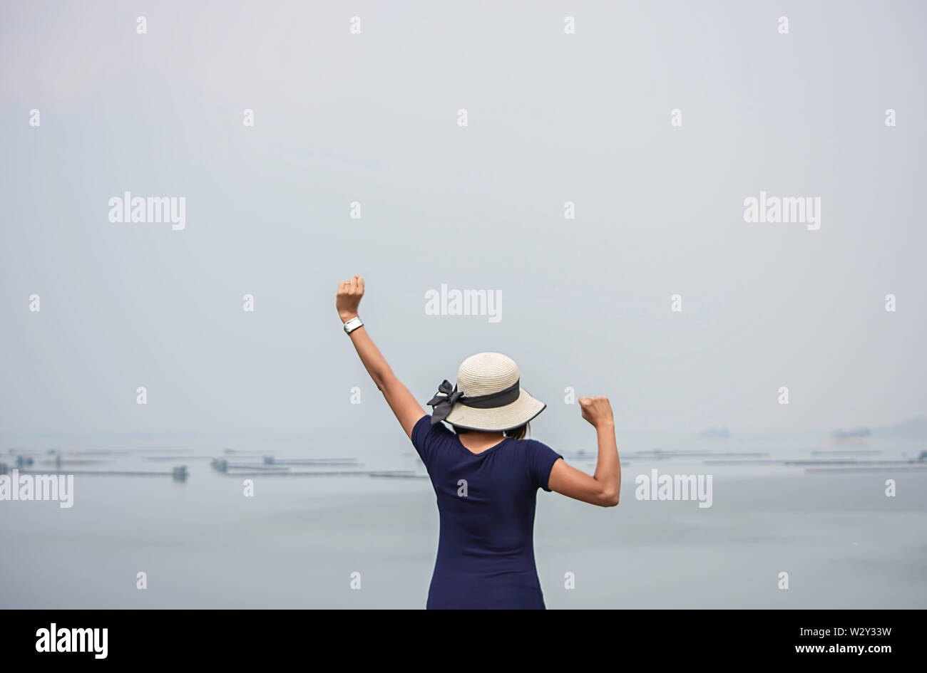 Women raise their arms Background The raft floating fish farming at ...