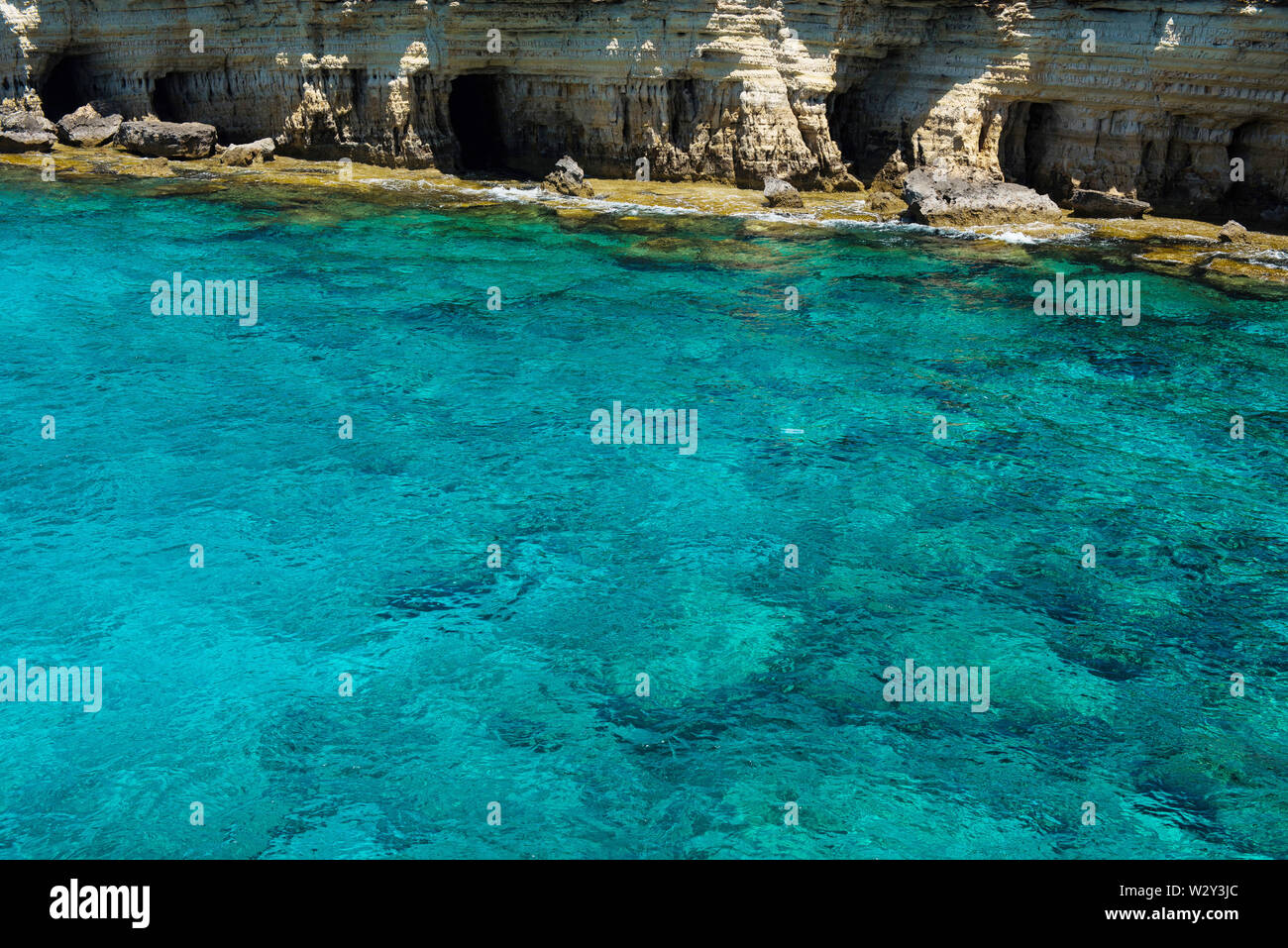 Turquoise sea water and littoral caves in Cyprus Stock Photo - Alamy