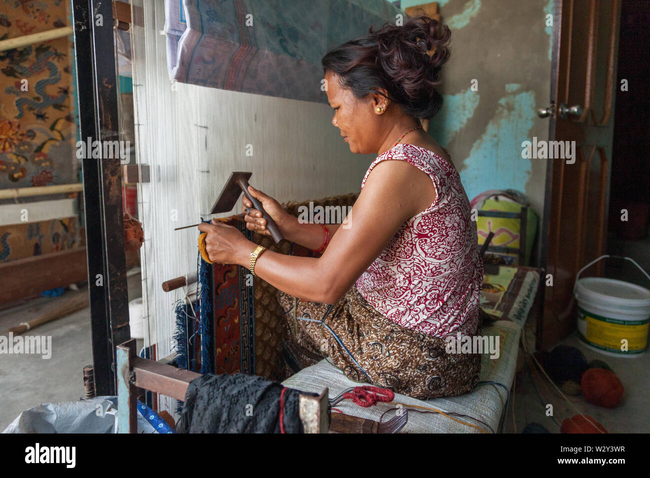 Women weaving rugs on a loom in her studio Stock Photo - Alamy