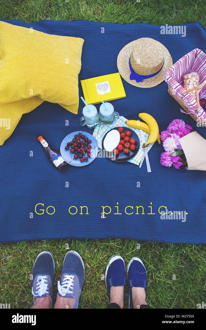 Bright picnic on the nature-flowers, delicious food, a loving couple ...