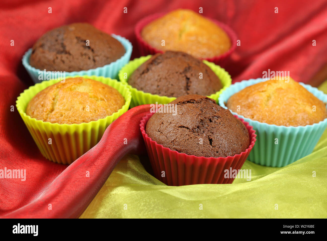 Muffins in colorful silicon moulds on red and green silk Stock Photo ...