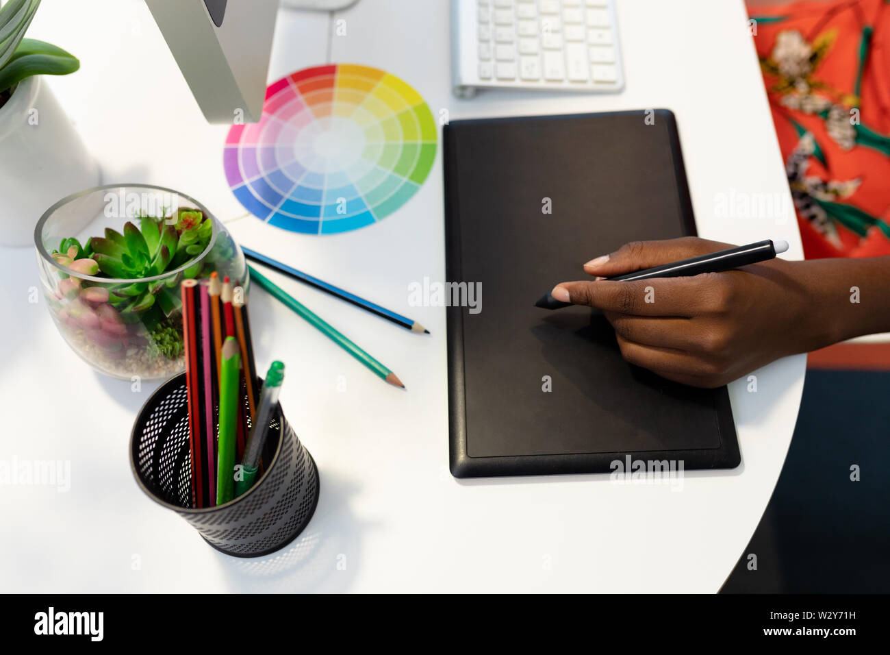 Female Graphic designer using graphic tablet at desk in office Stock ...