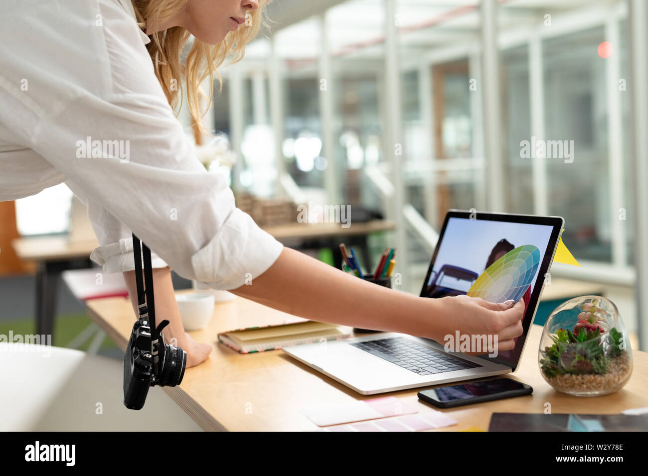 Female graphic designer looking at color swatch in office Stock Photo ...