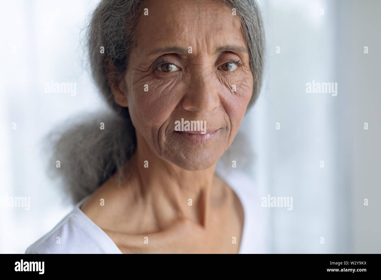 Woman standing inside white room Stock Photo - Alamy
