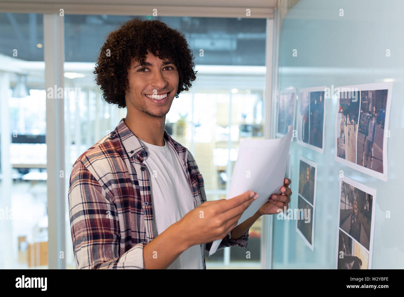 Happy male graphic designer holding a paper Stock Photo - Alamy