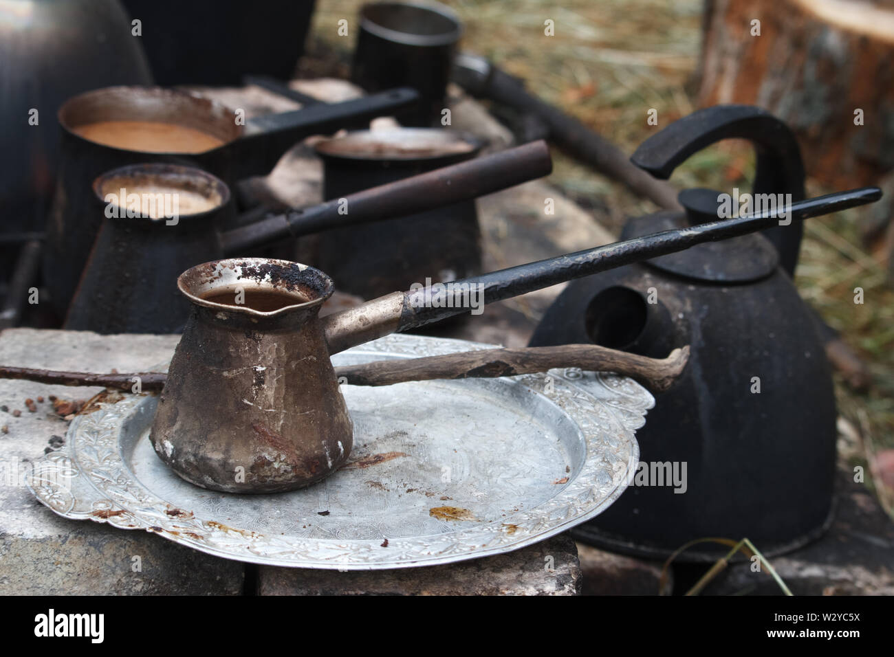 Boiling coffee in turkish cezva on a grate over a burning bonfire ...