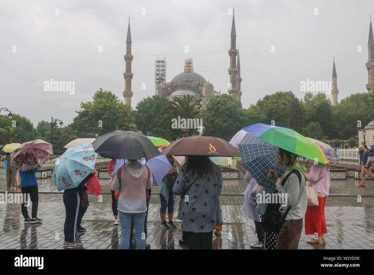 Istanbul Turkey. 11th July 2019. Tourists shelter with umbrellas form ...