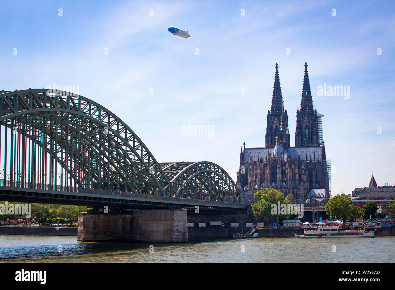 Zeppelin airship above Cologne cathedral and Hohenzollern bridge over ...