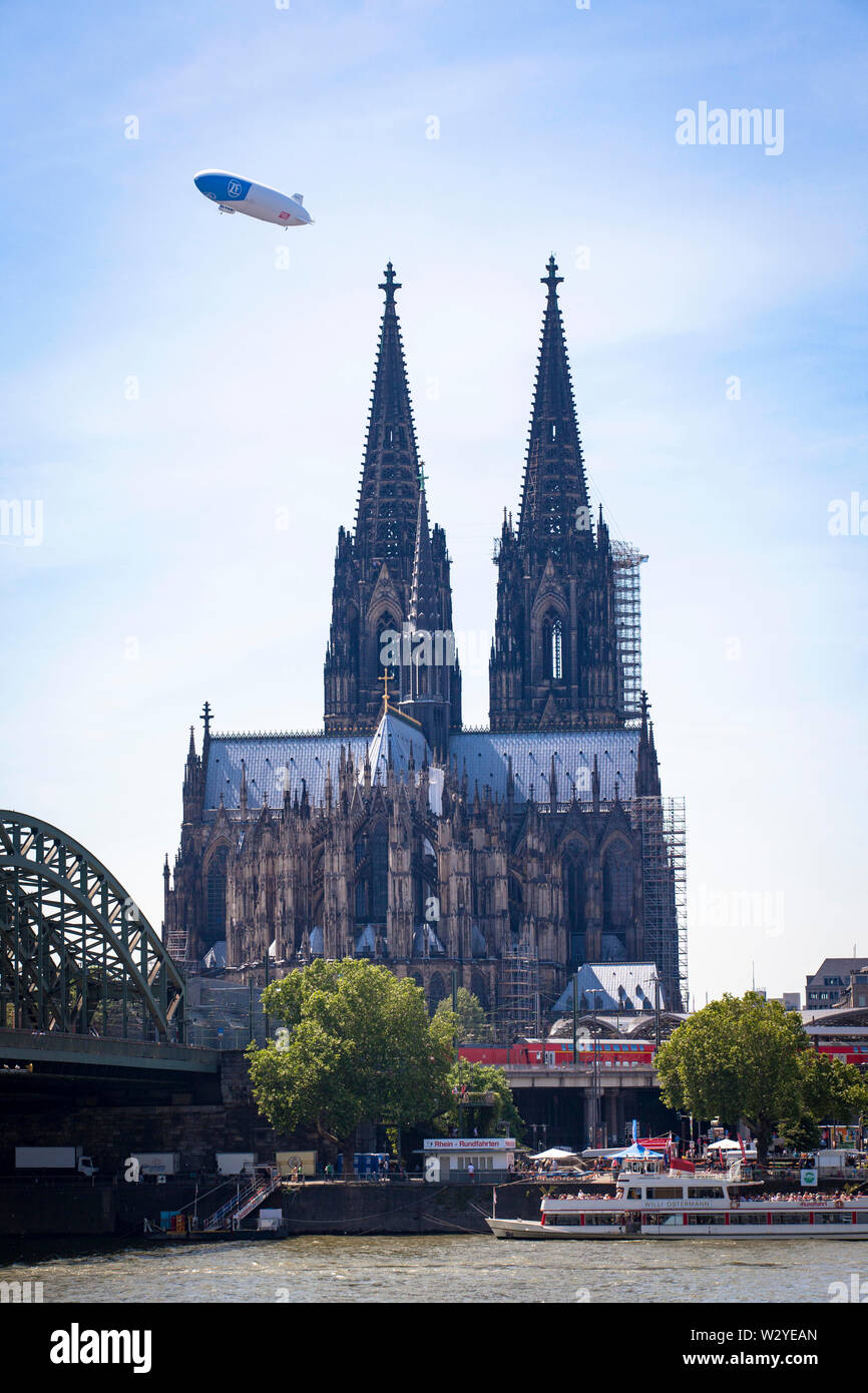 Zeppelin airship above Cologne cathedral, Hohenzollern bridge over the ...