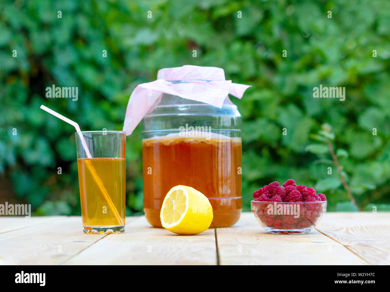 Glass jar with Kombucha, poured glass with Kombucha and raspberries in ...