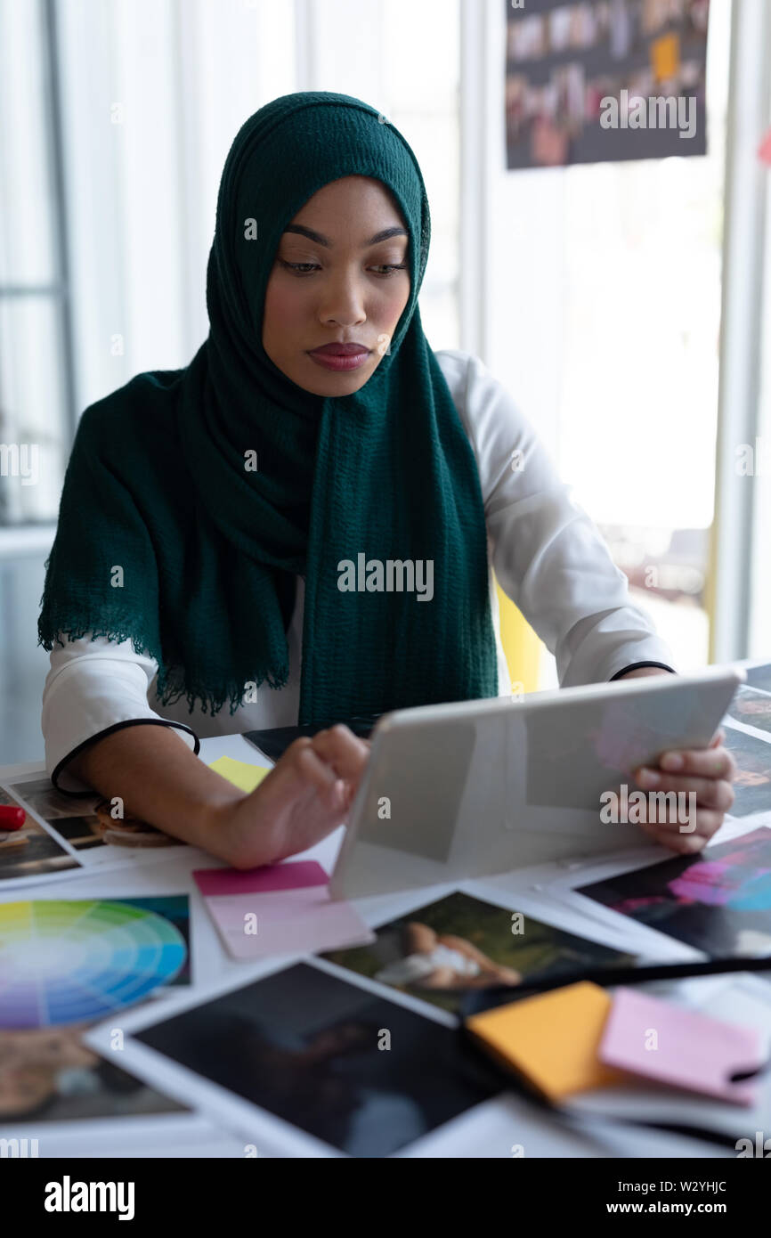 Female graphic designer in hijab using digital tablet at desk Stock ...