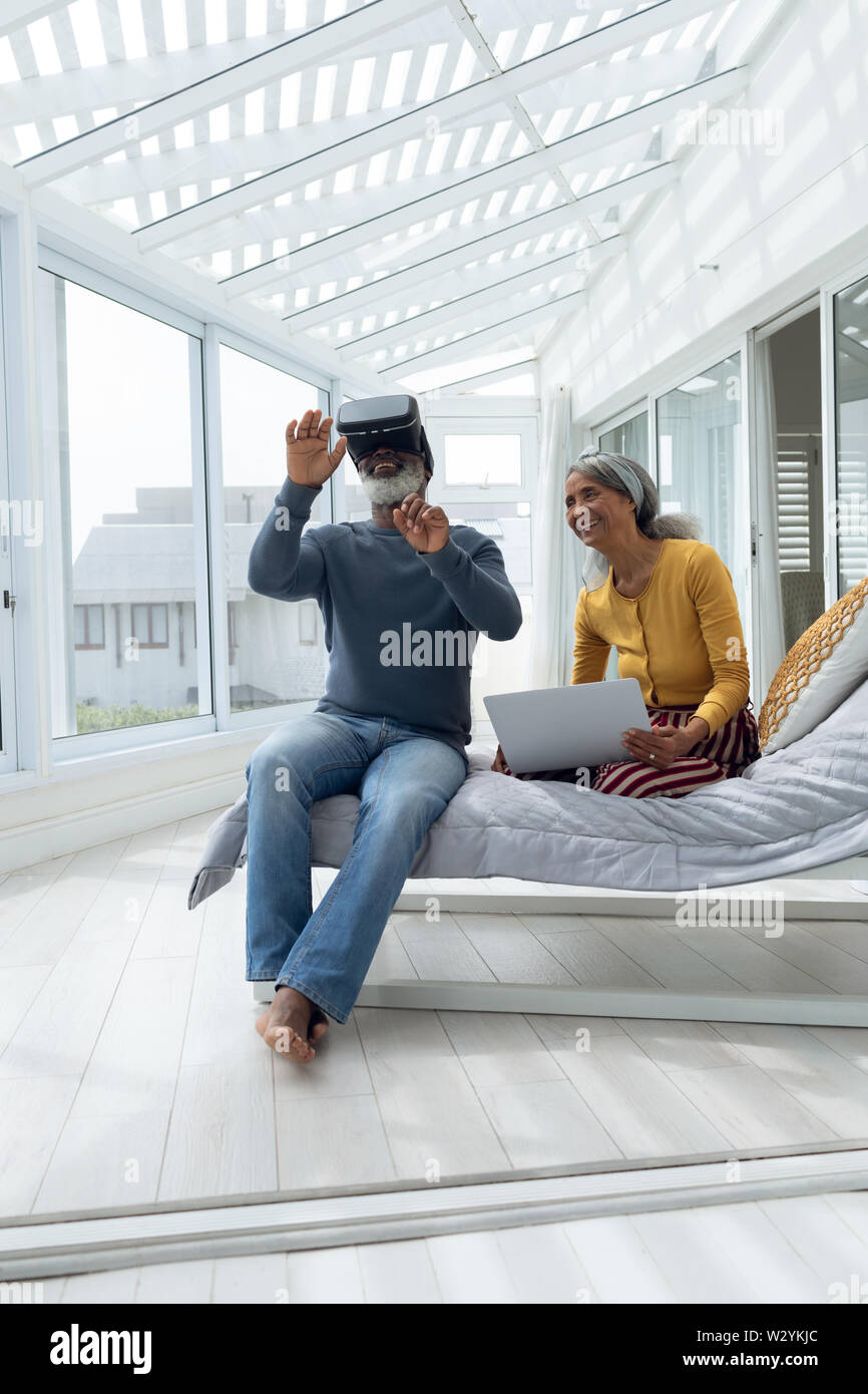 Couple sitting on a bed while using digital devices Stock Photo - Alamy