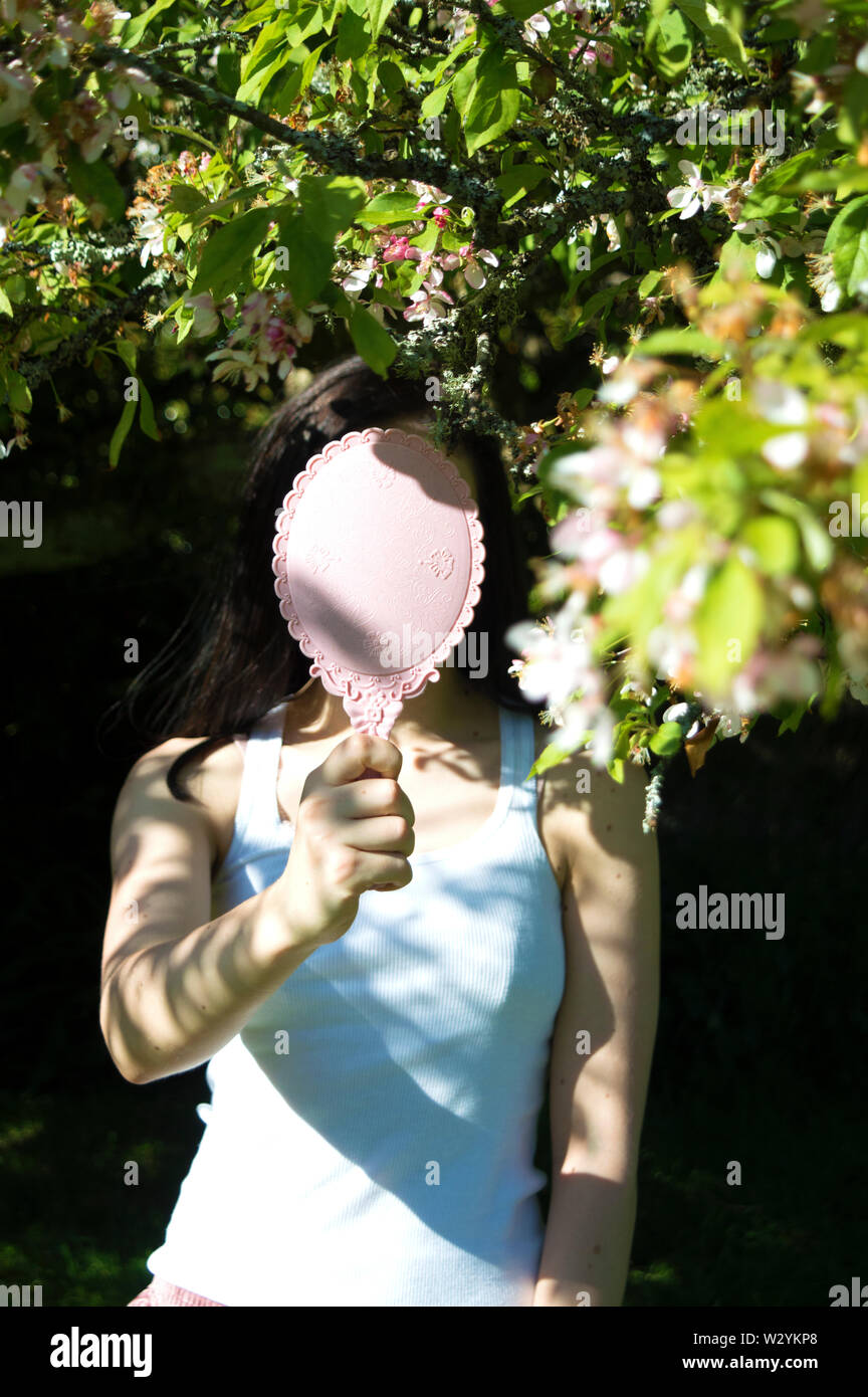 A self-portrait with a blossom tree and a pink mirror hiding my face ...
